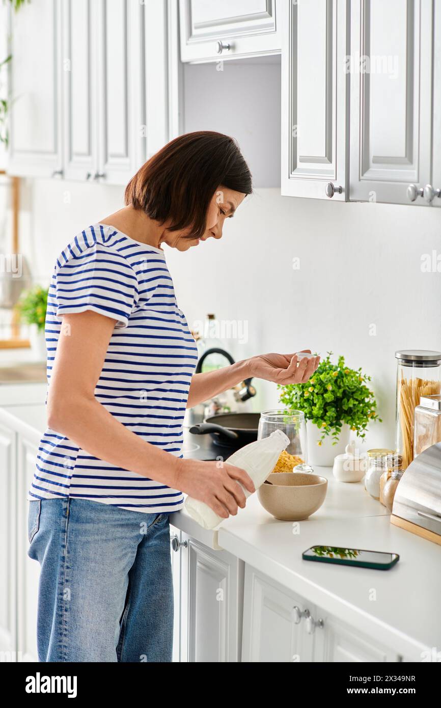 A woman in cozy attire stands in a kitchen, preparing food with focus ...