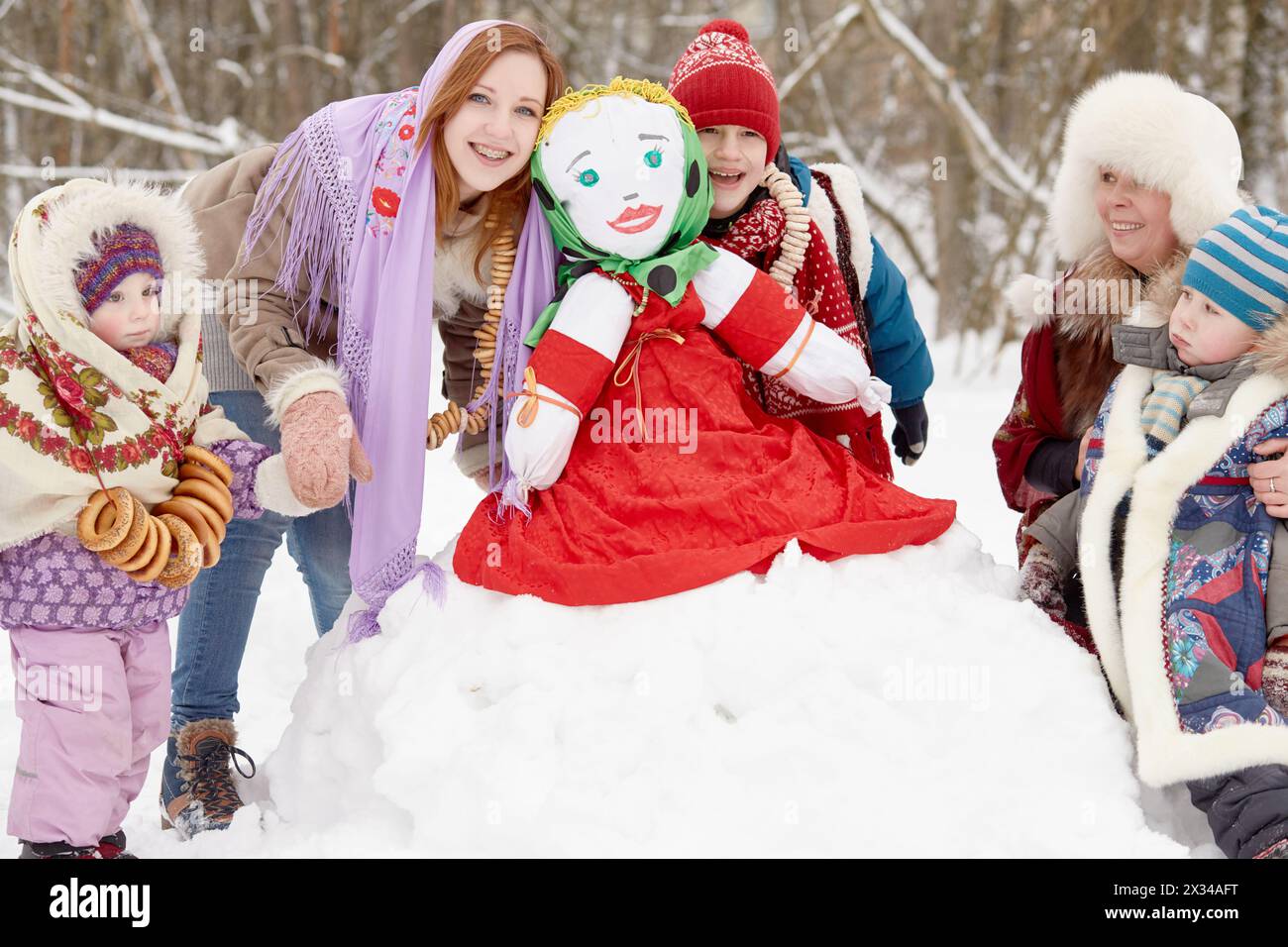 Woman and four children of different age around stuffed dummy ...