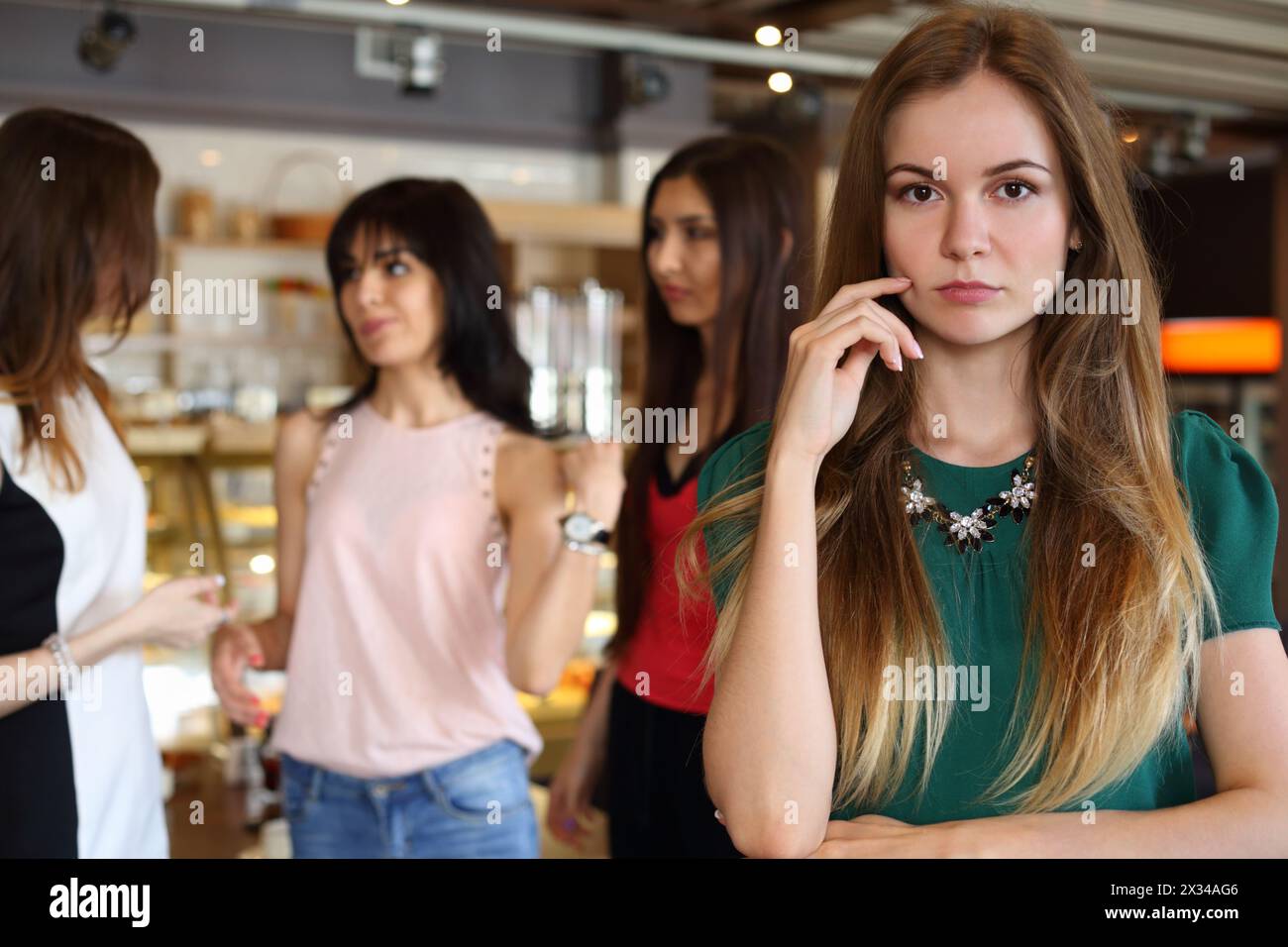 Pretty woman gestures in cafe and three girls talk out of focus Stock ...