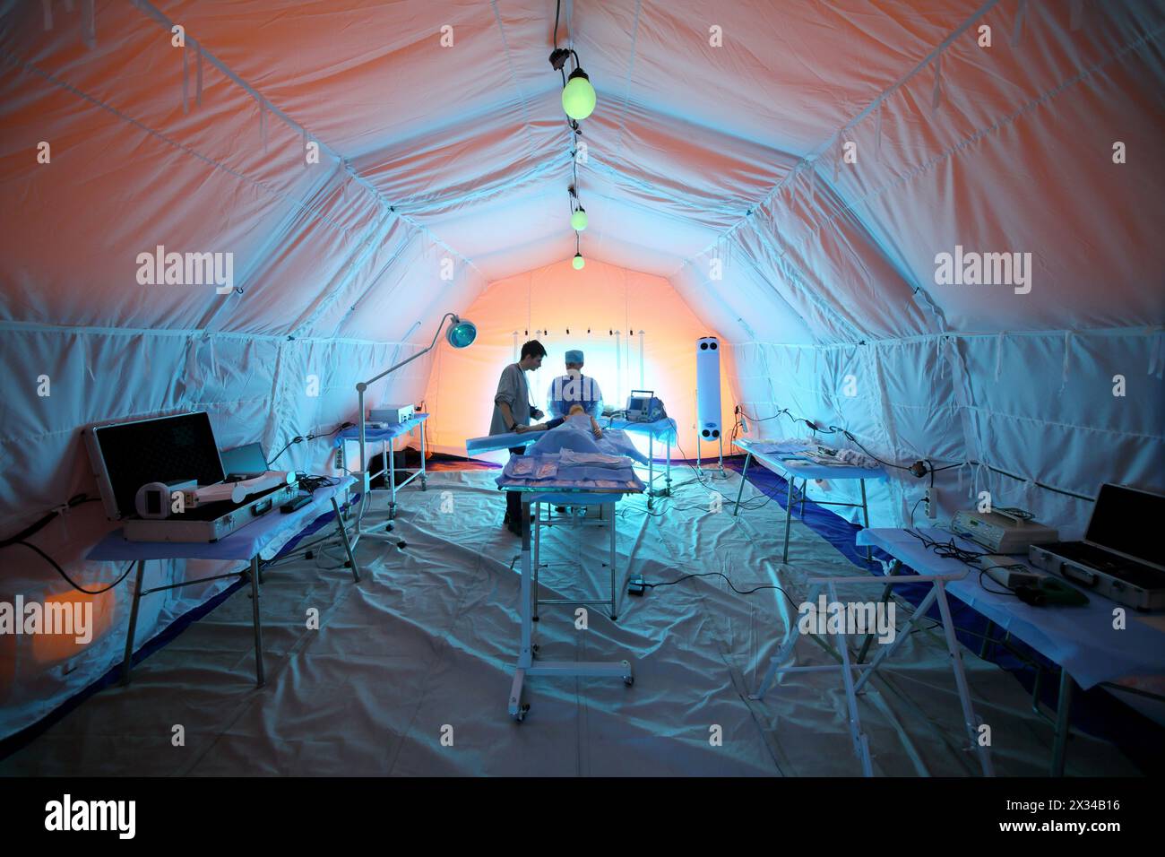 Medical worker and a student near the lying dummy inside the tent in a ...
