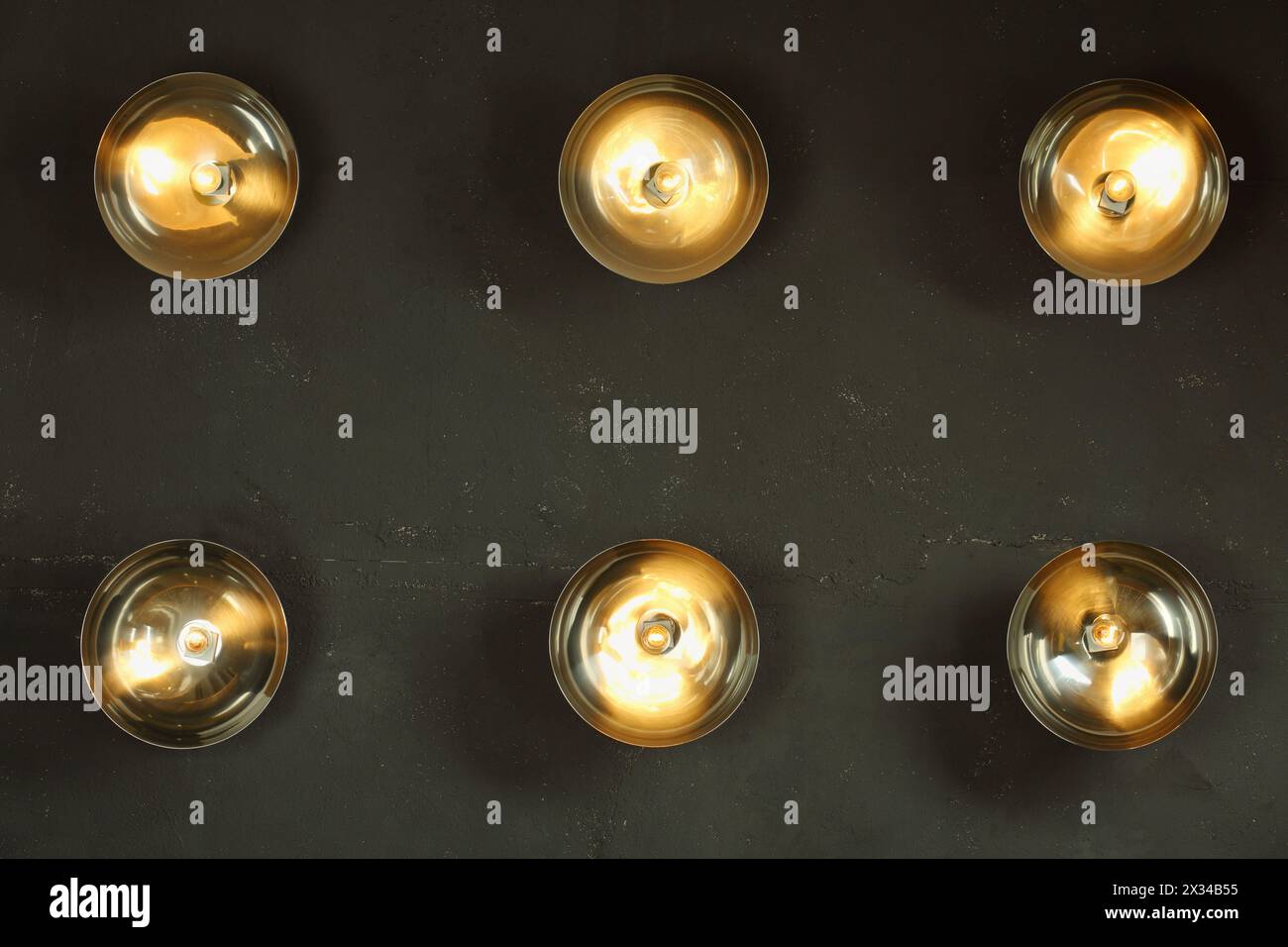 Six round lamps with lamp shades are on black wall in studio Stock ...