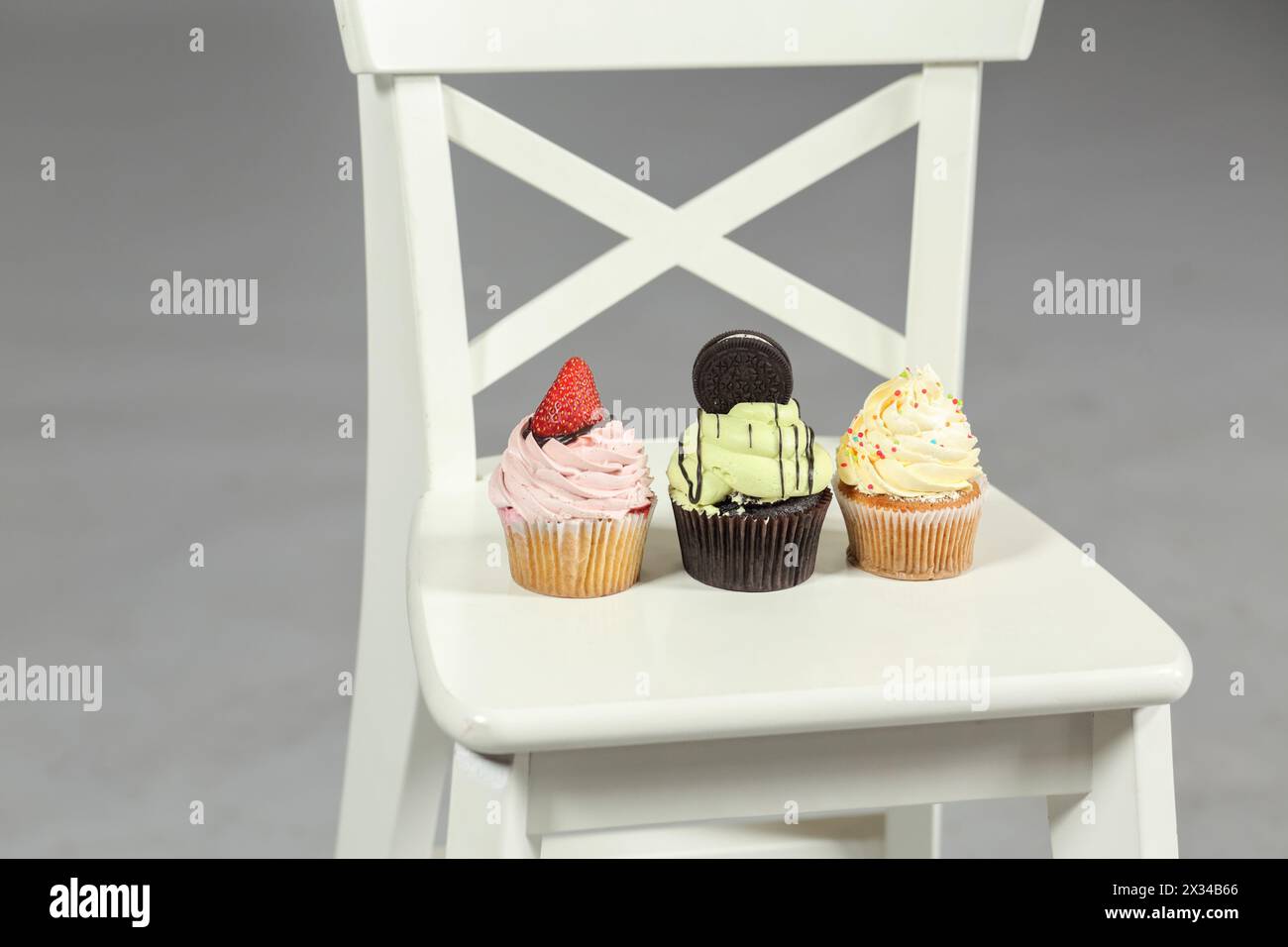 three cakes: with strawberries, cookies, whipped cream stand on white ...
