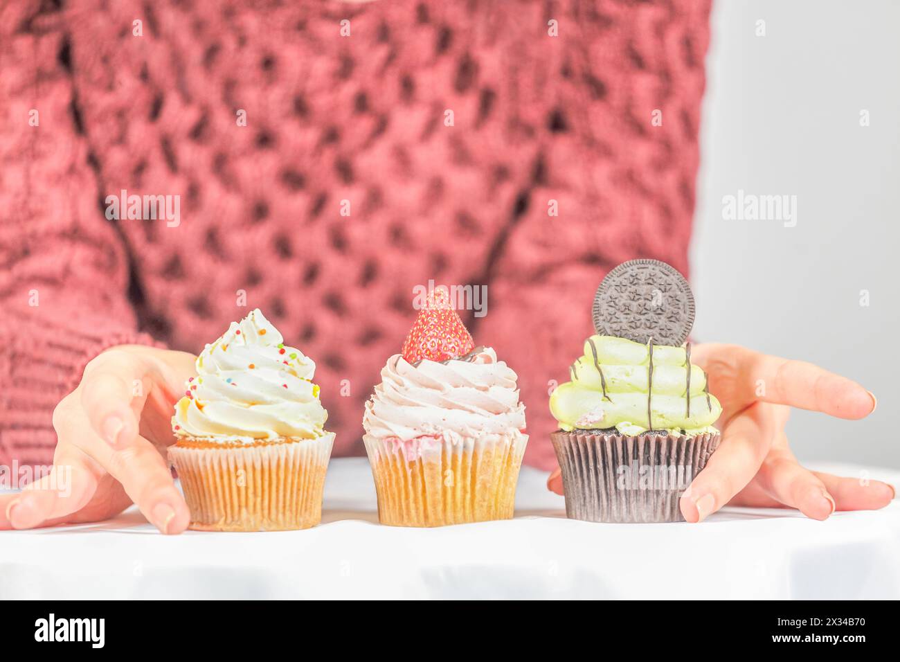 Three cakes on table with strawberries, cookies and whipped cream, girl ...