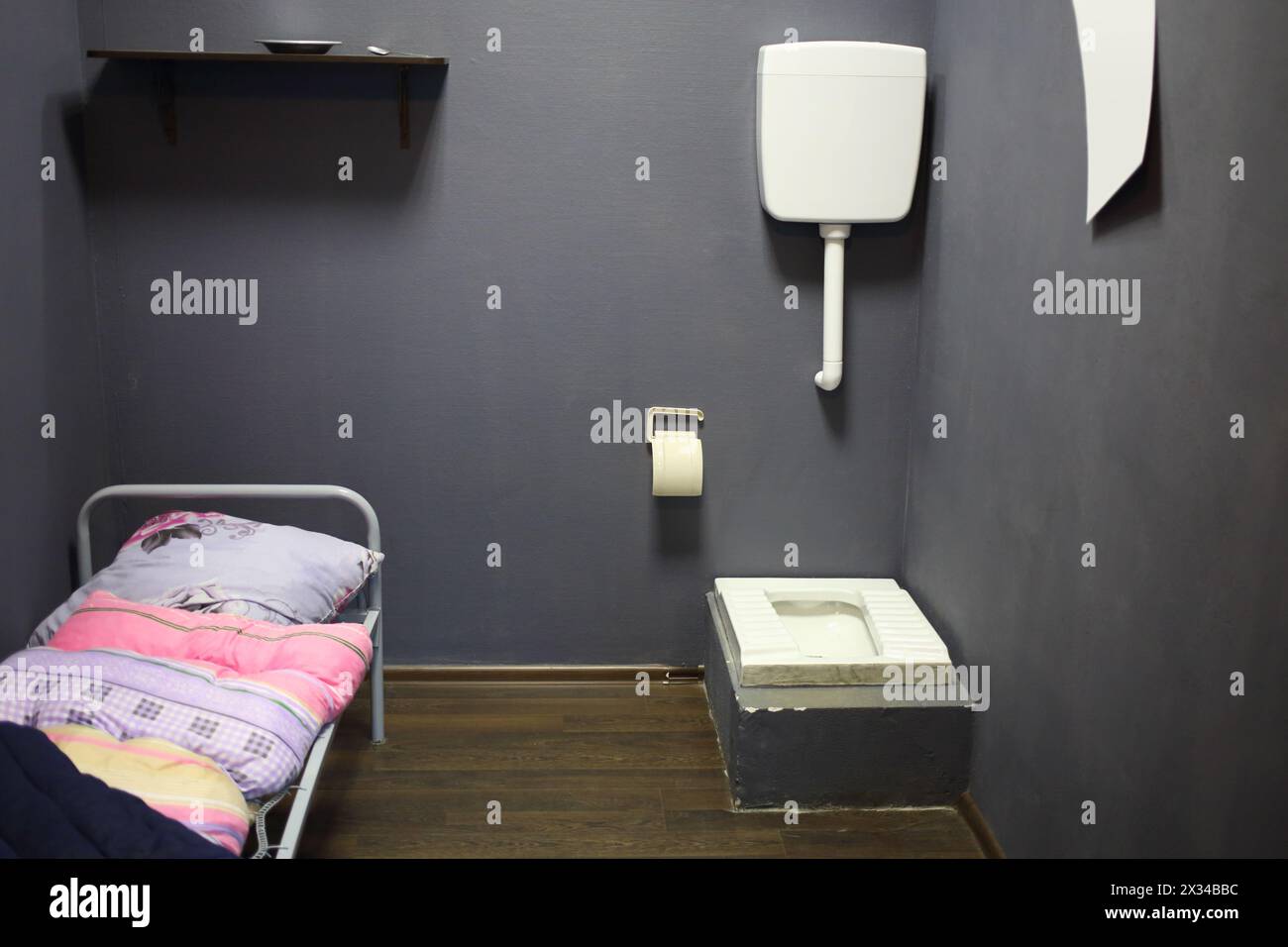 Simple stylized interior of a prison cell with a bed and a toilet Stock ...
