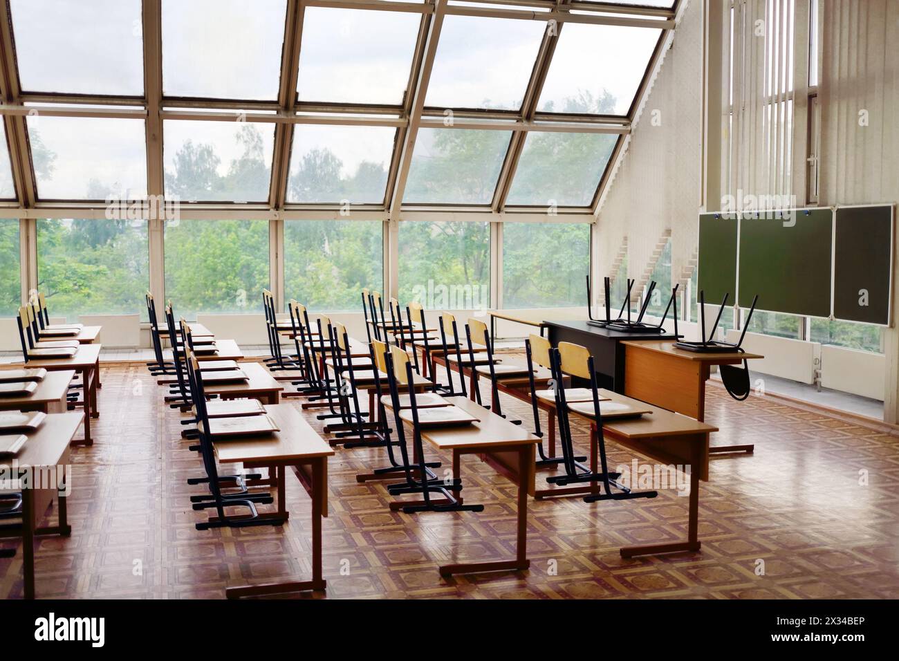 Modern empty classroom with chairs on desks with bid window at summer ...