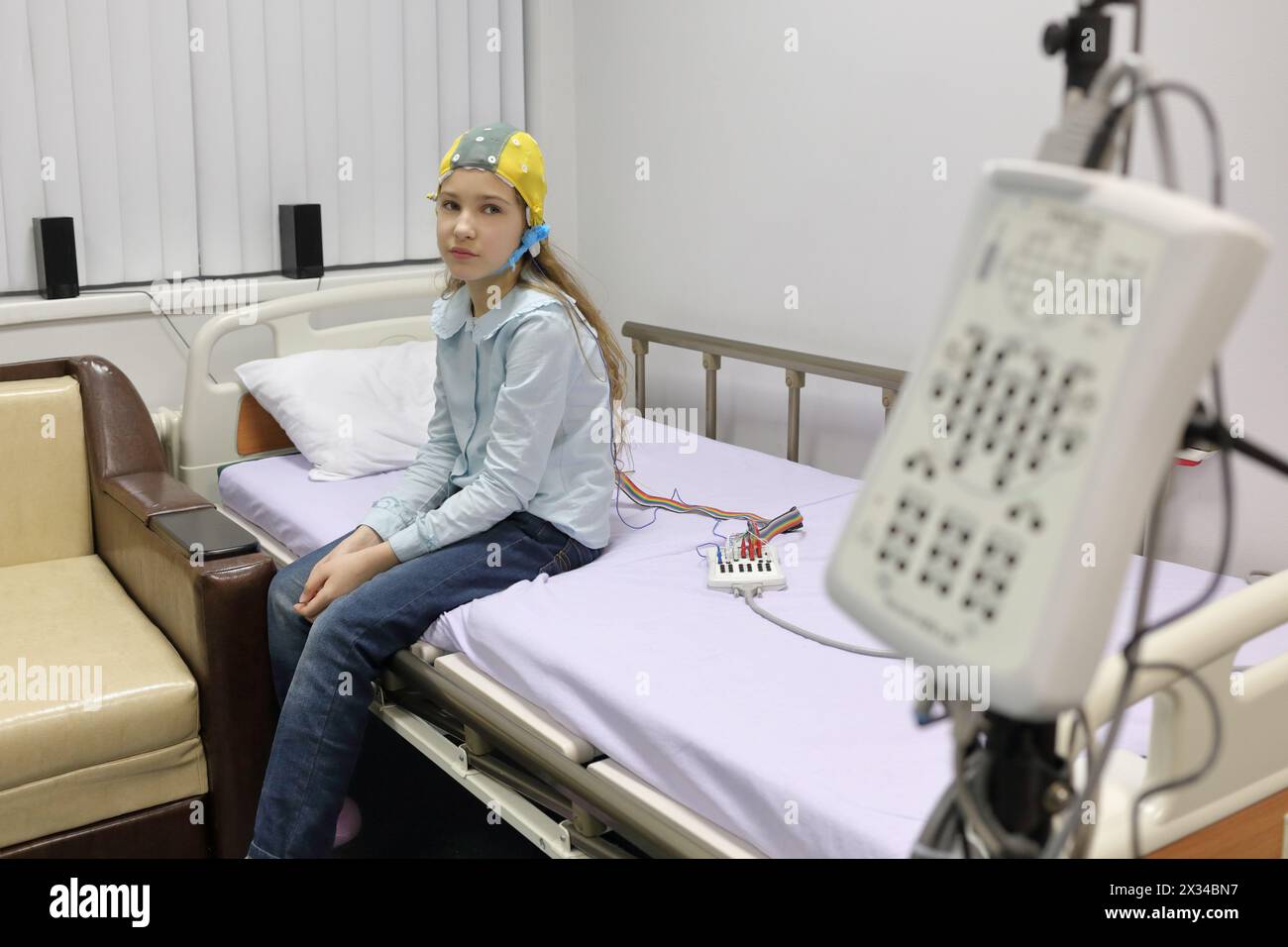 patient girl on procedure of recording of electroencephalogram, sitting ...