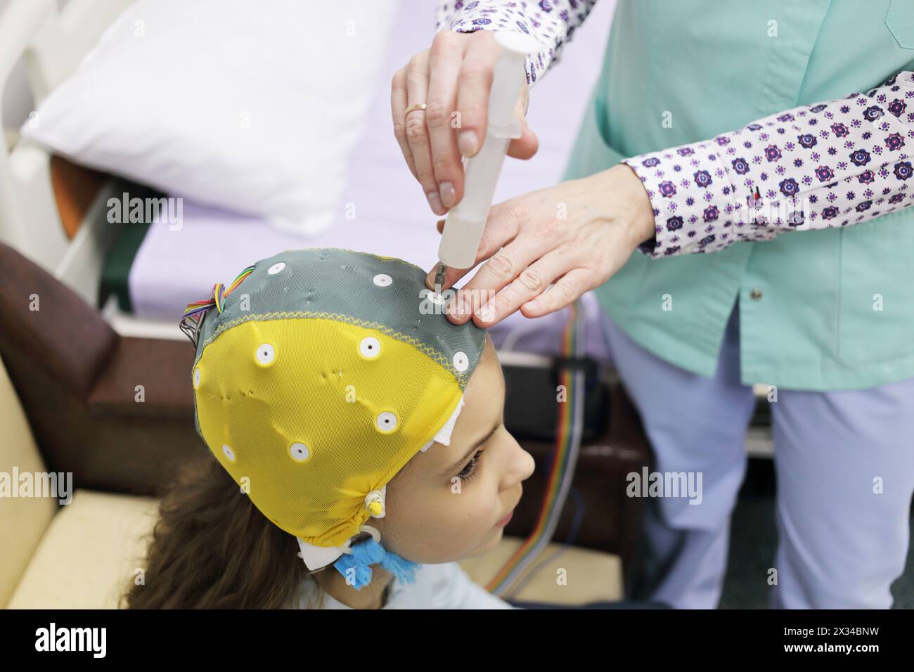 Girl before procedure electroencephalography, nurse using syringe ...