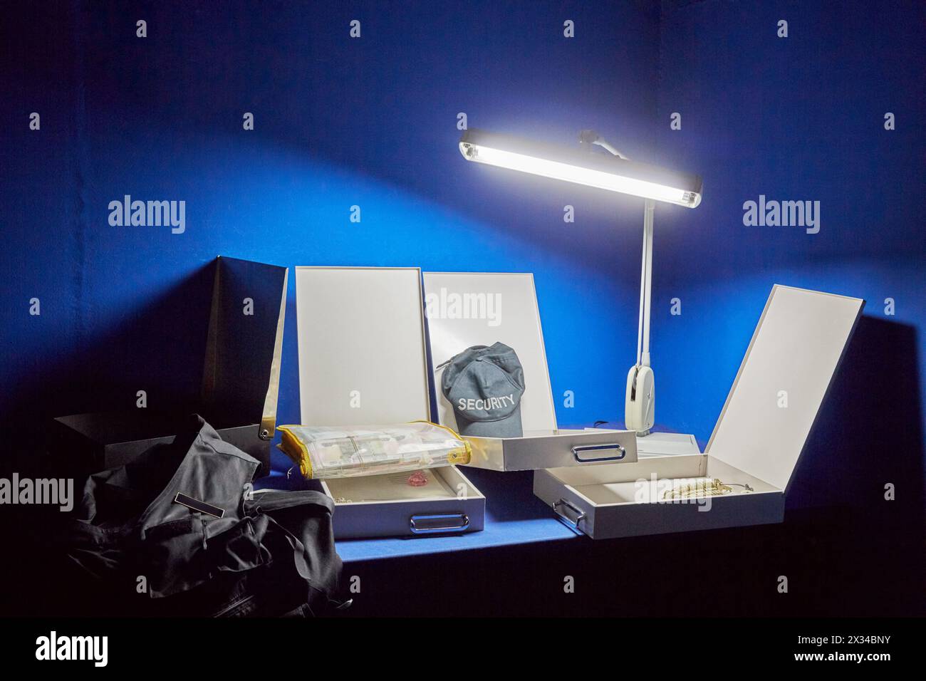 Table with boxes with keys, money pack, cap and jacket under bright ...