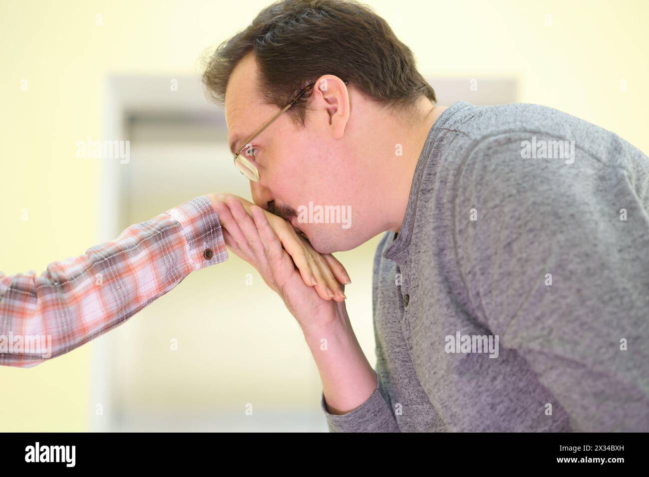 The man with glasses and a mustache kissing womens hands near the ...