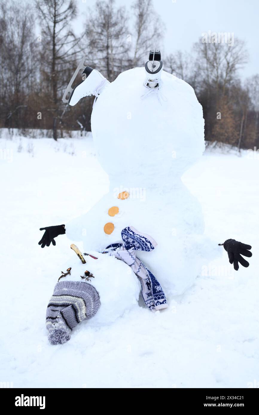 Upside down snowman with grey hat, scarf and skates at winter day Stock ...