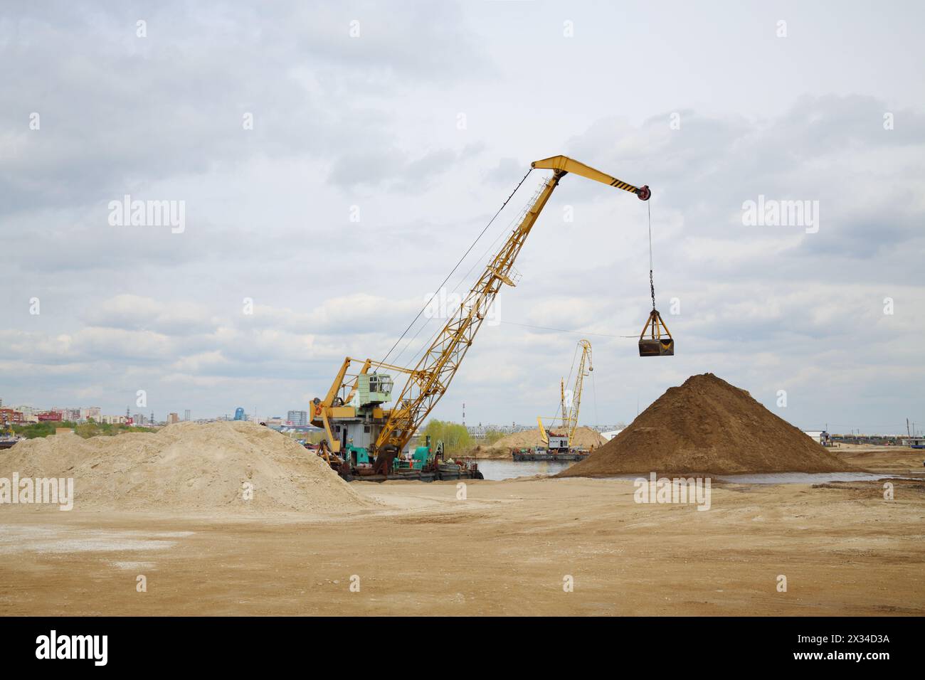 Cranes work at dock on River and huge piles of sand at spring day Stock ...