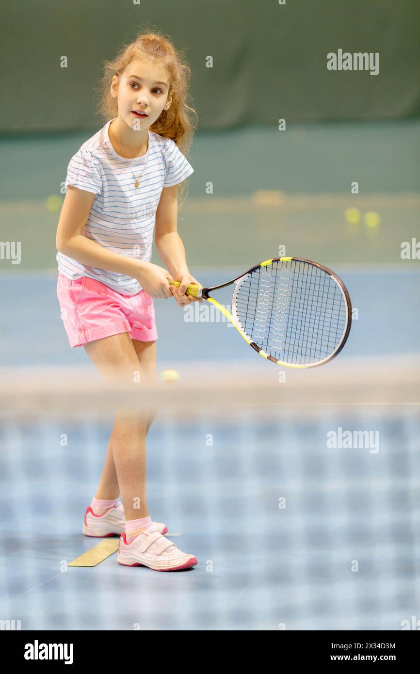 young female tennis player on tennis court holding racquet, in gym, waiting for service Stock ...