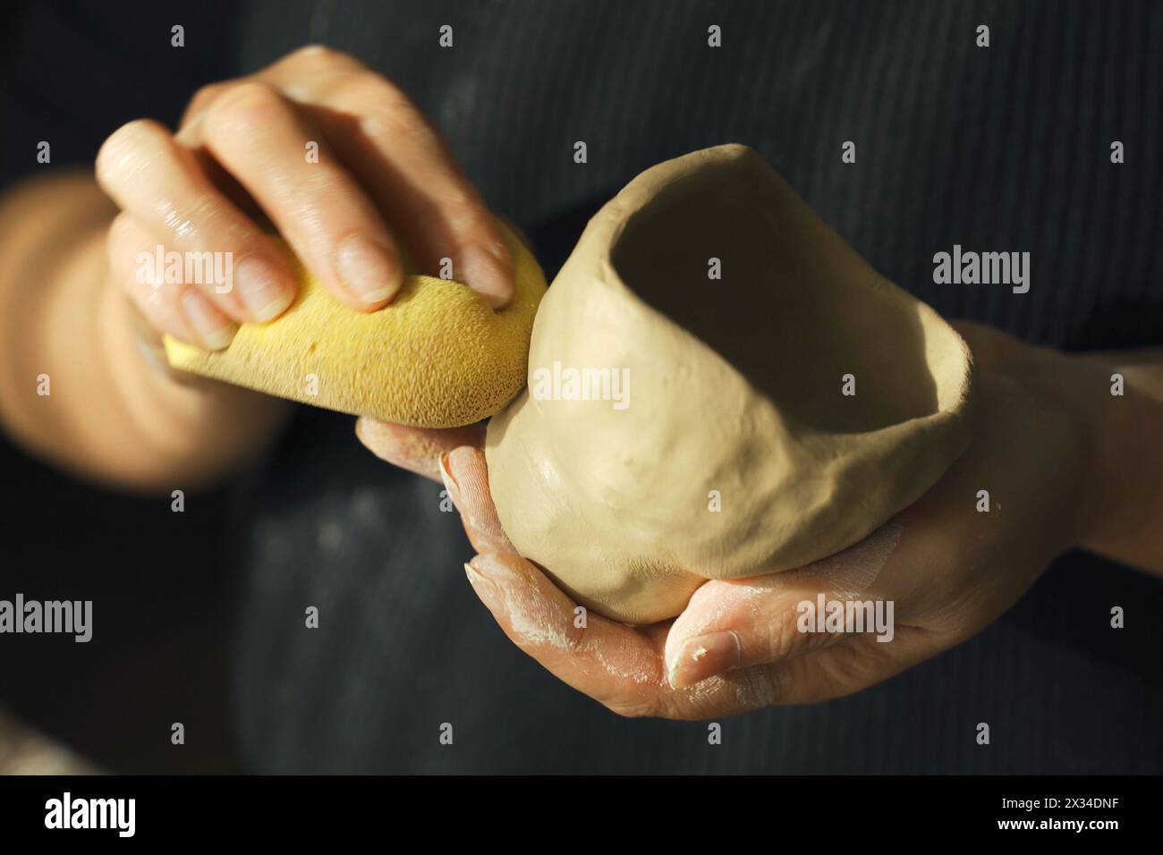 Hand sculpting of clay ceramics, shaping the volume of the craft using ...