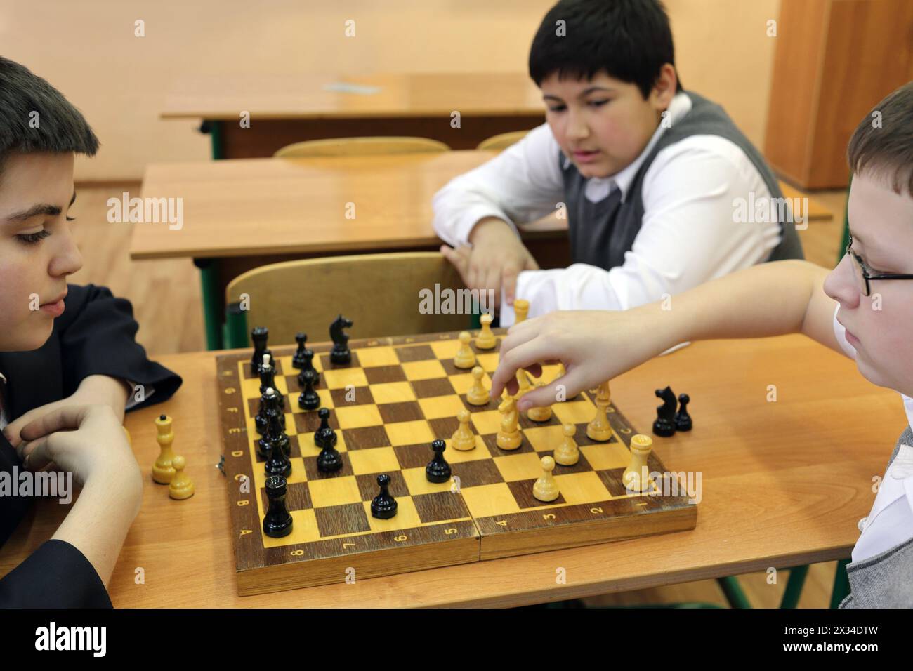two students during break between lessons in classroom to play chess ...