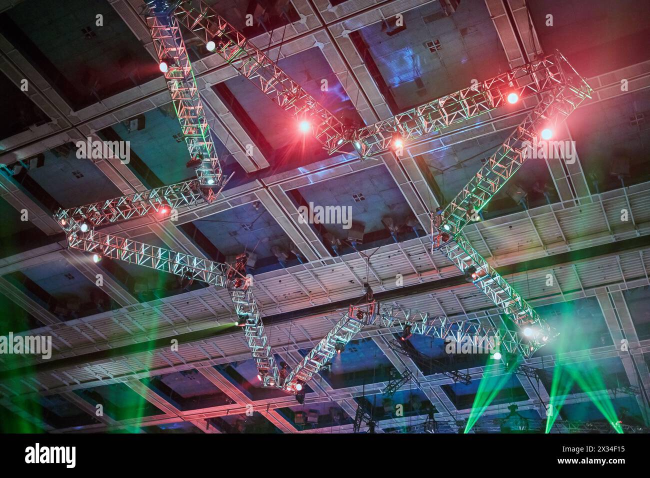 Working light devices and beams of color lights at construction in shape of star on ceiling ...