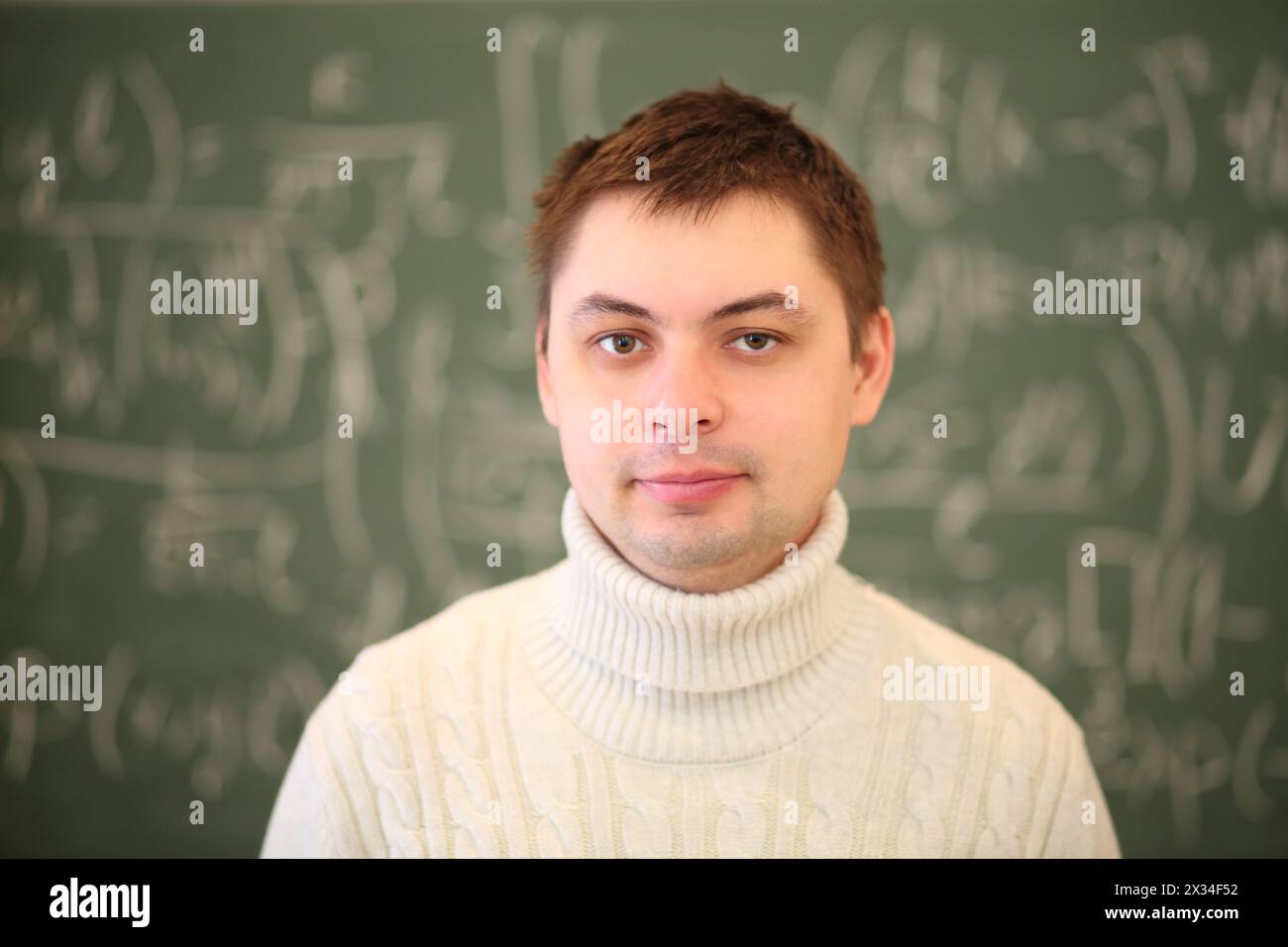 Teacher in white stands near blackboard with mathematics formulas in ...