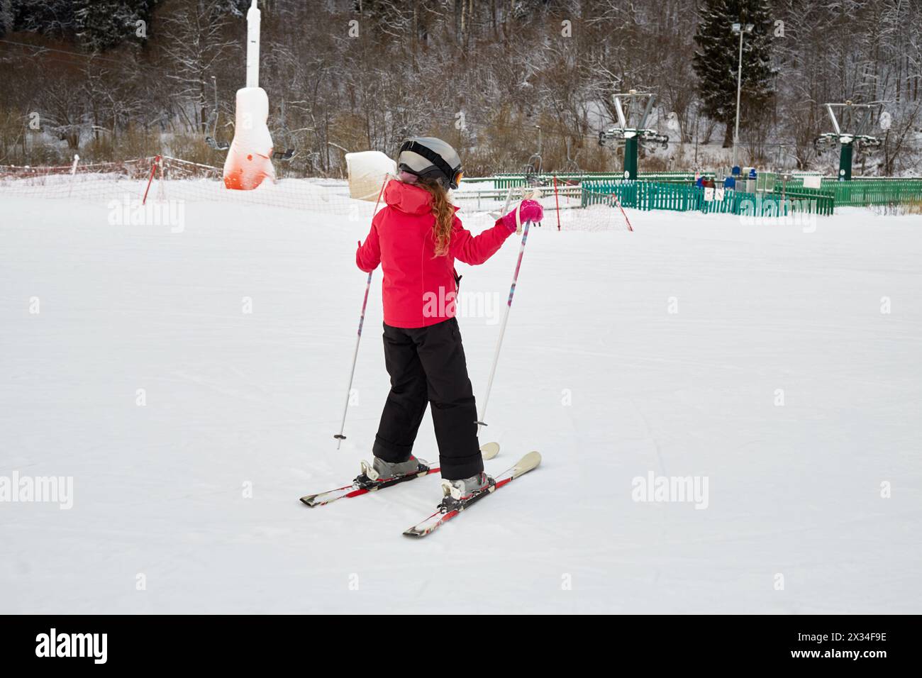 Teenage girl equipped for skiing on snowy slope at ski resort Stock ...