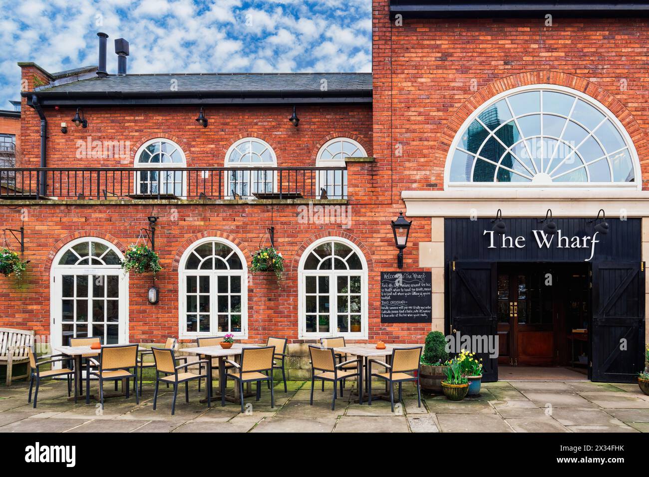 Manchester, UK The Wharf pub facade with outdoor seating in the ...