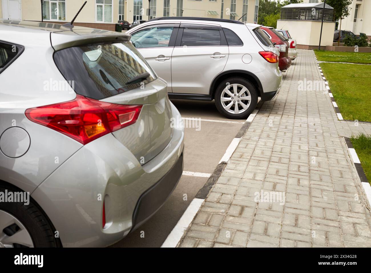 Several modern cars stand at parking places in courtyard Stock Photo ...