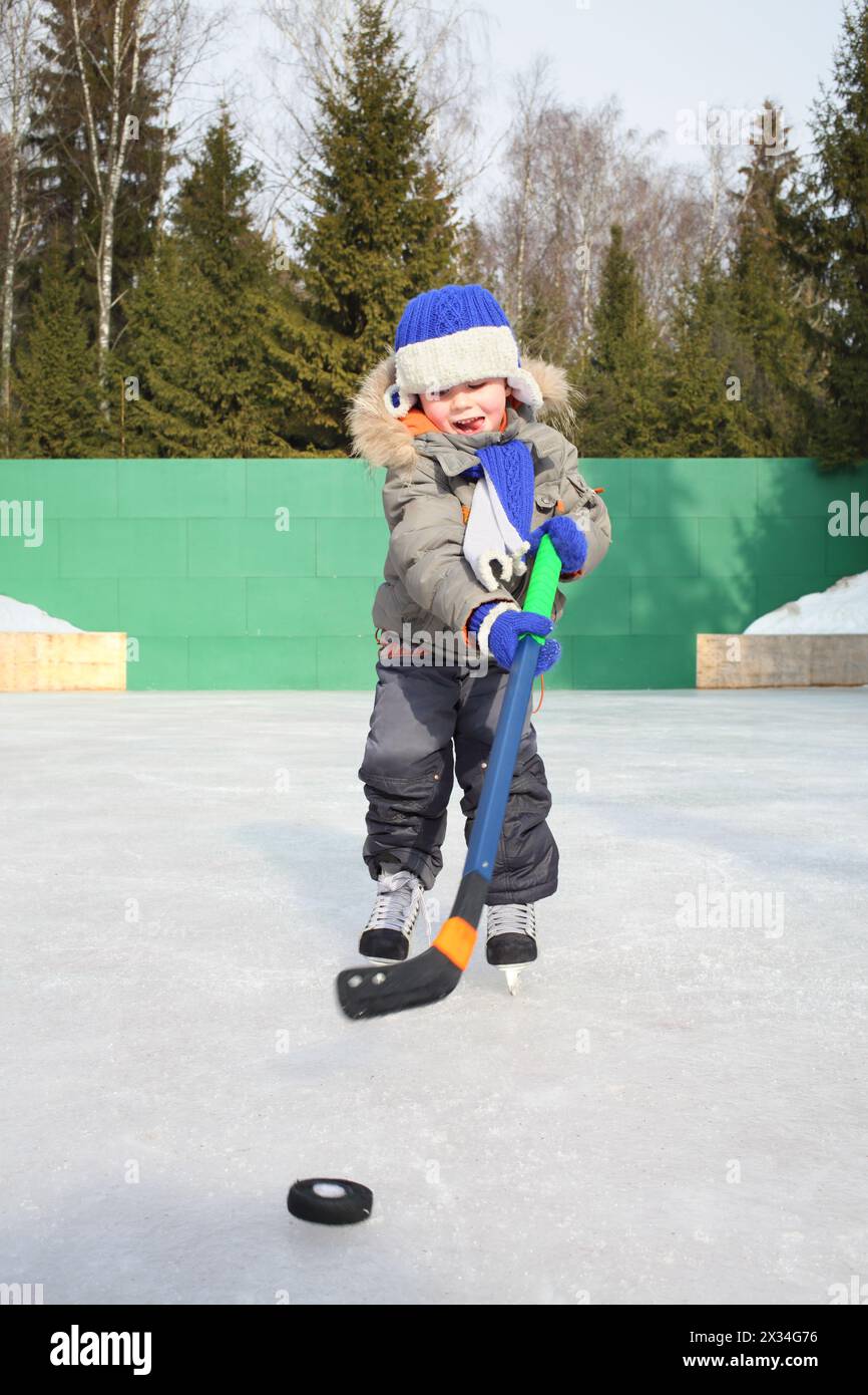 Happy little boy on skates with a hockey stick and puck Stock Photo - Alamy
