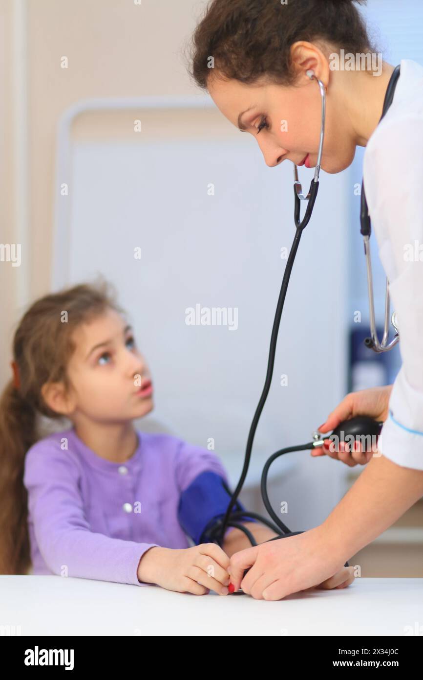 Doctor measures blood pressure girl patient, focus on woman Stock Photo ...