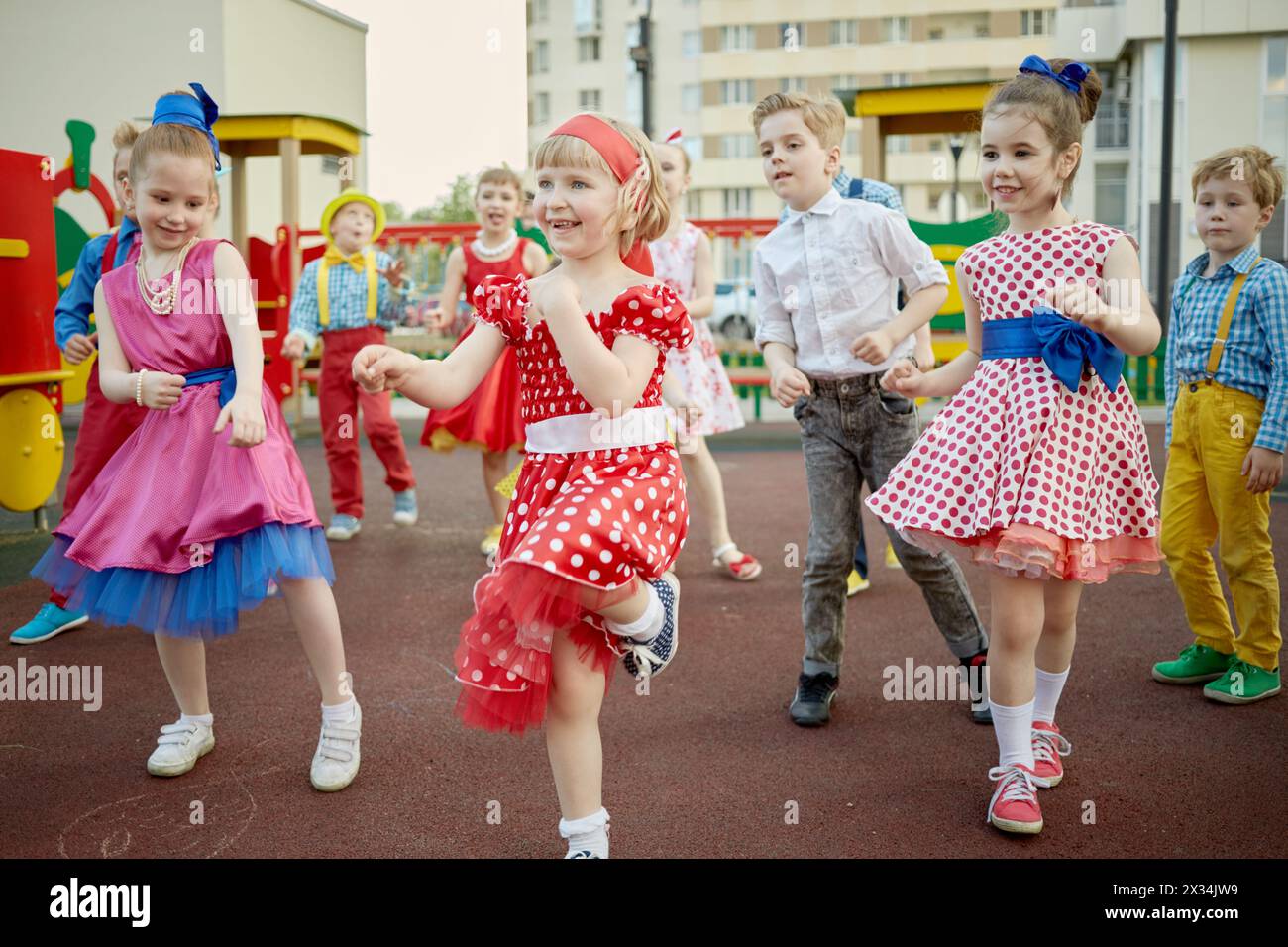 Ten children dance at playground in courtyard Stock Photo - Alamy
