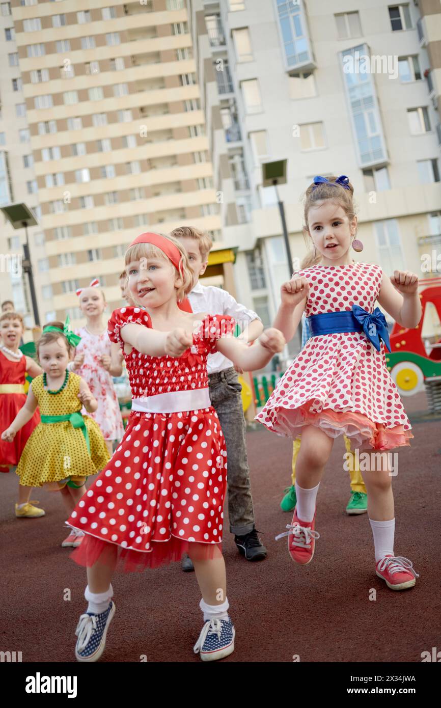 Seven children dance at playground in courtyard Stock Photo - Alamy