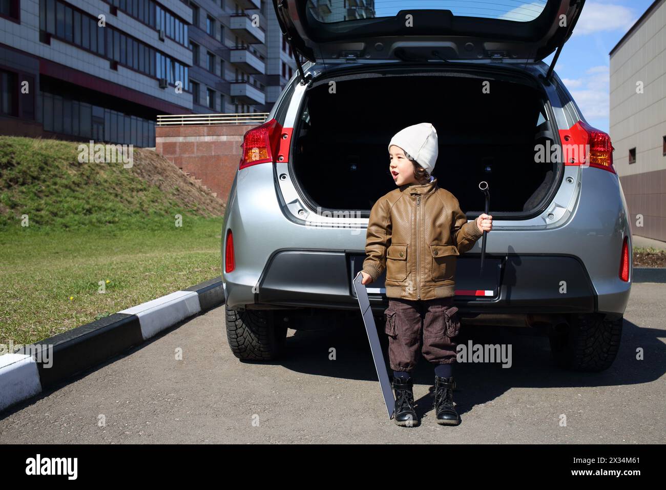 Little boy in white hat standing with machine number and socket wrench ...