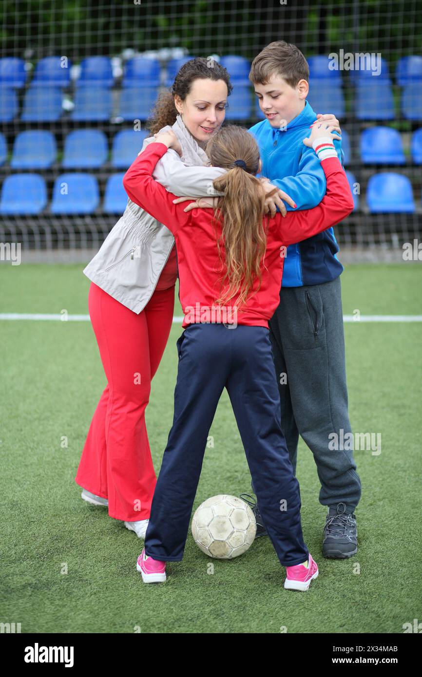 Mother with son and daughter standing with his hands on the shoulders ...