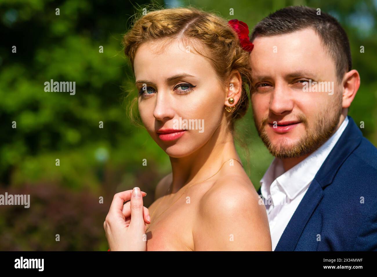 Man in suit and young woman hug and pose in summer garden, close up ...