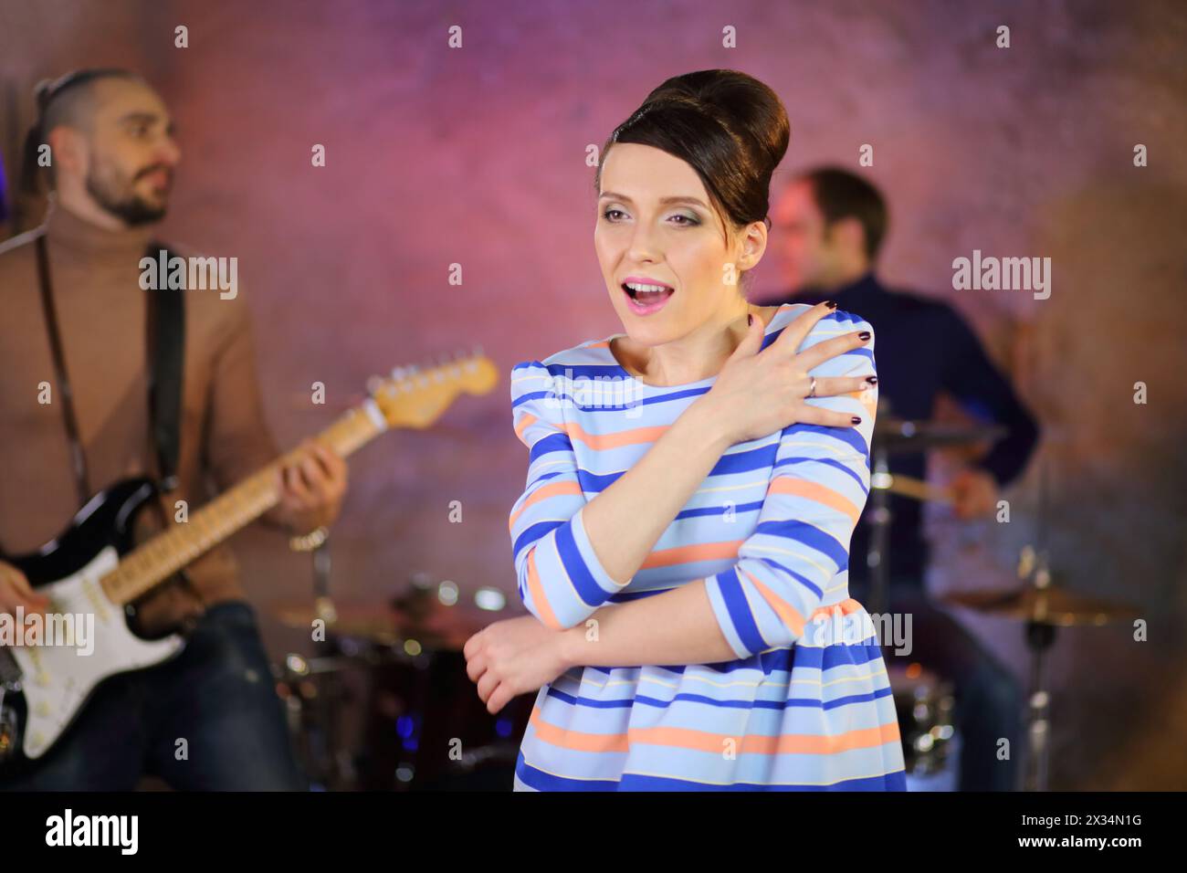 Beautiful retro singer sings a song with feeling near musicians Stock ...