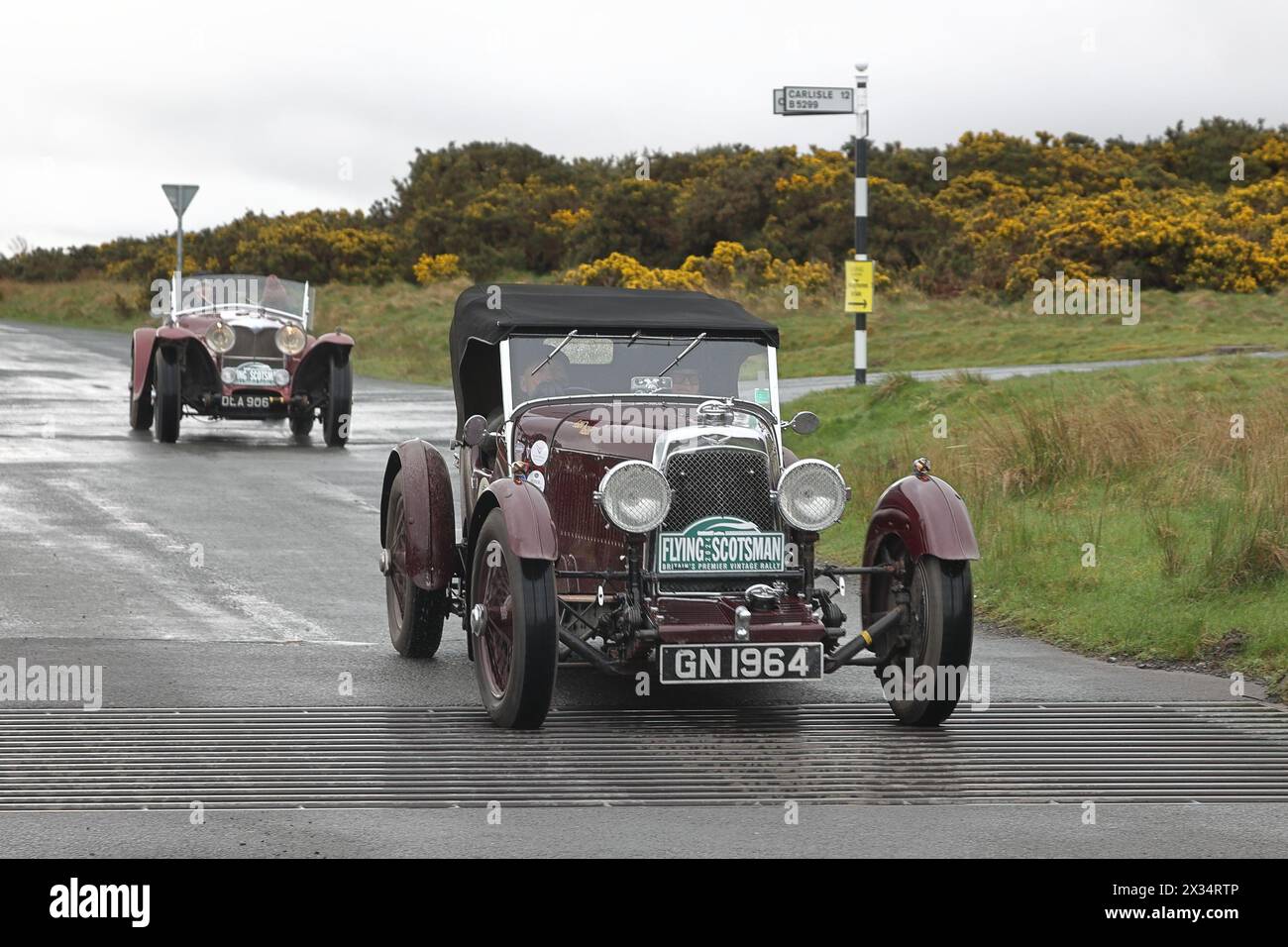 A procession of vintage cars leave Caldbeck, Cumbria. The cars are ...