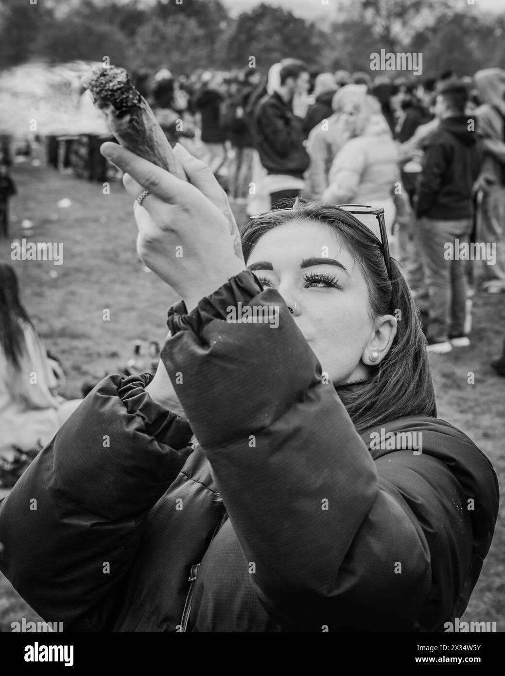 Black and white image of a woman smoking a large cannabis joint during ...
