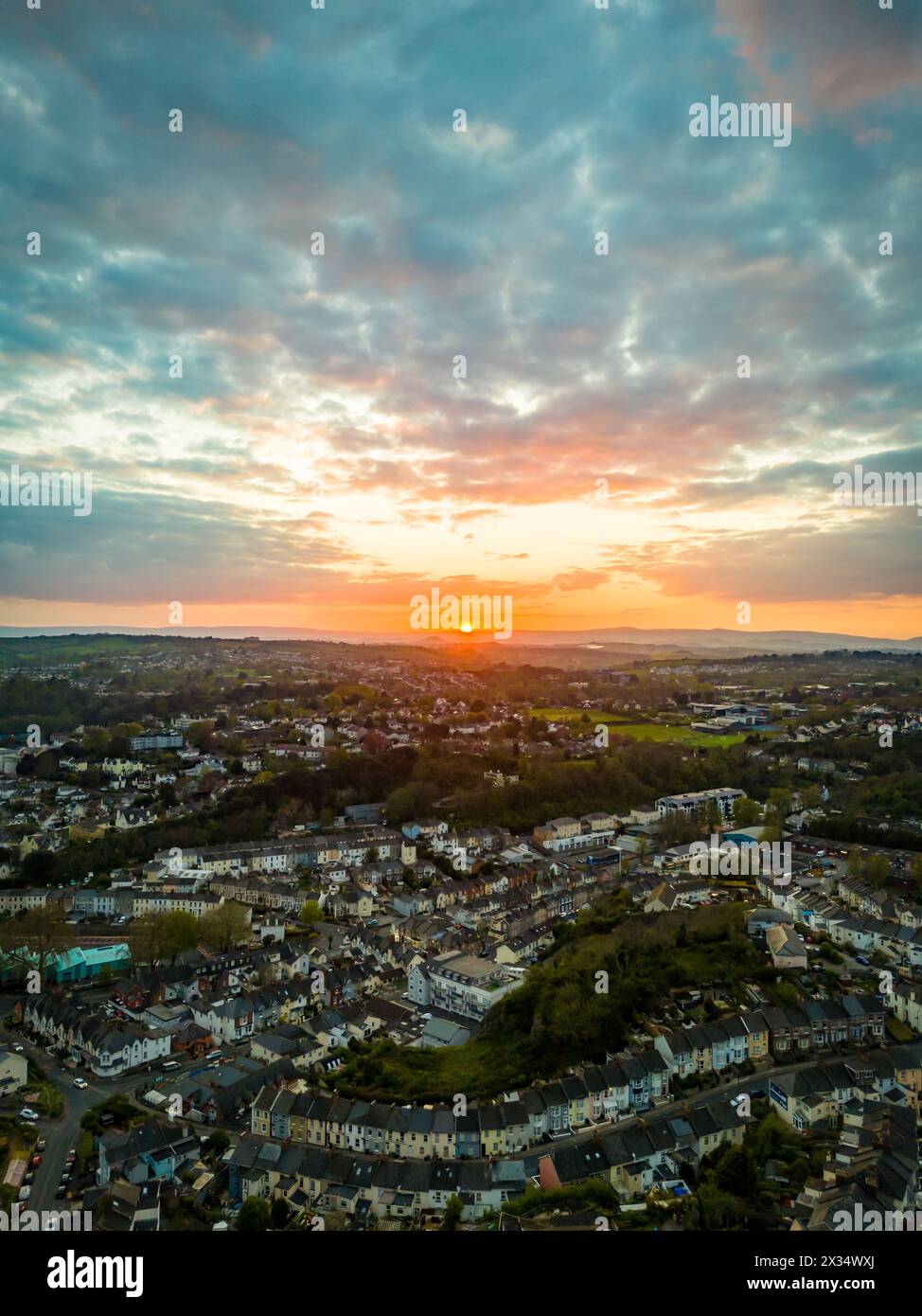 Torquay, UK. 24th Apr, 2024. Sunset over the Devon hills and the town ...