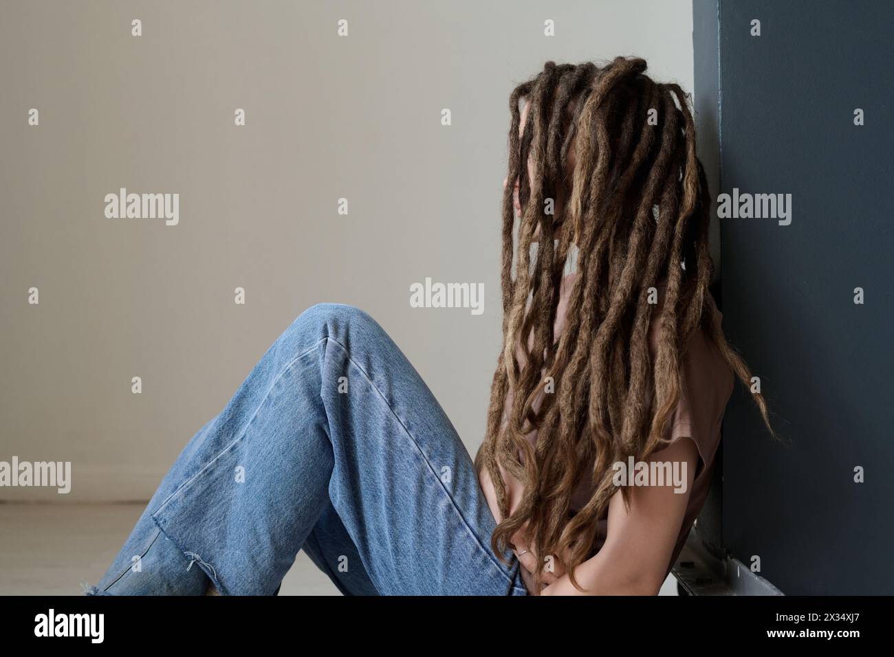 Side view portrait of unrecognizable woman with long dreadlocks sitting ...