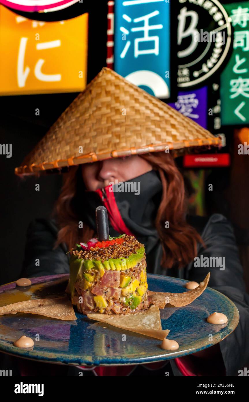Redhead in japanese disguise and conical hat serving a salmon tartar ...