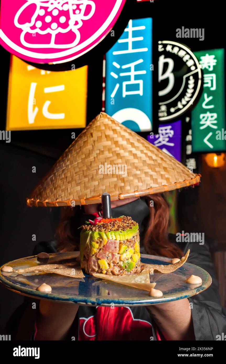 Redhead in japanese disguise and conical hat serving a salmon tartar ...