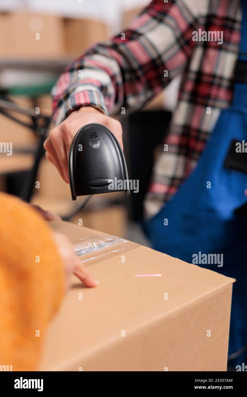 Warehouse employee scanning cardboard box barcode while doing inventory control. Delivery ...