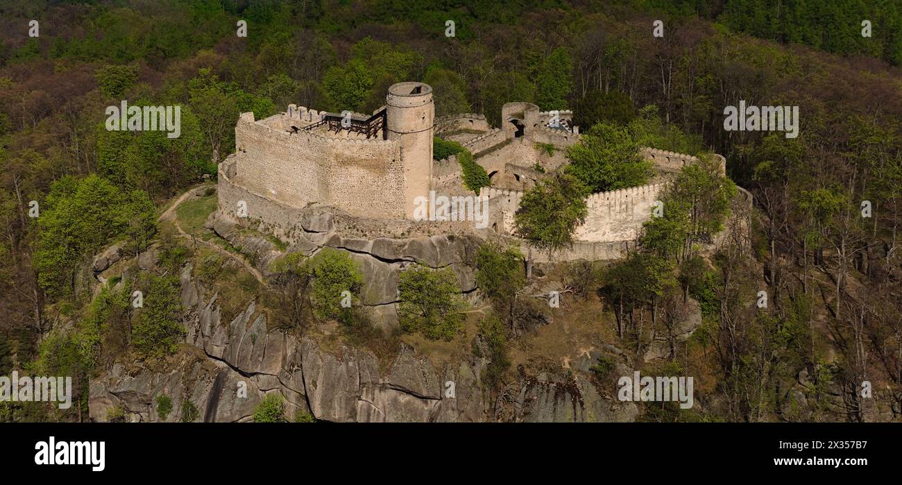 An aerial view captures the medieval Chojnik Castle atop a mountain in ...