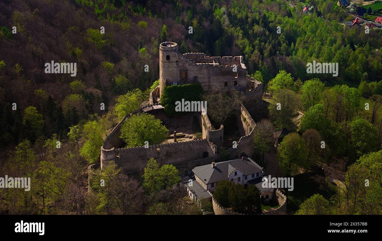 An aerial view captures the medieval Chojnik Castle atop a mountain in ...