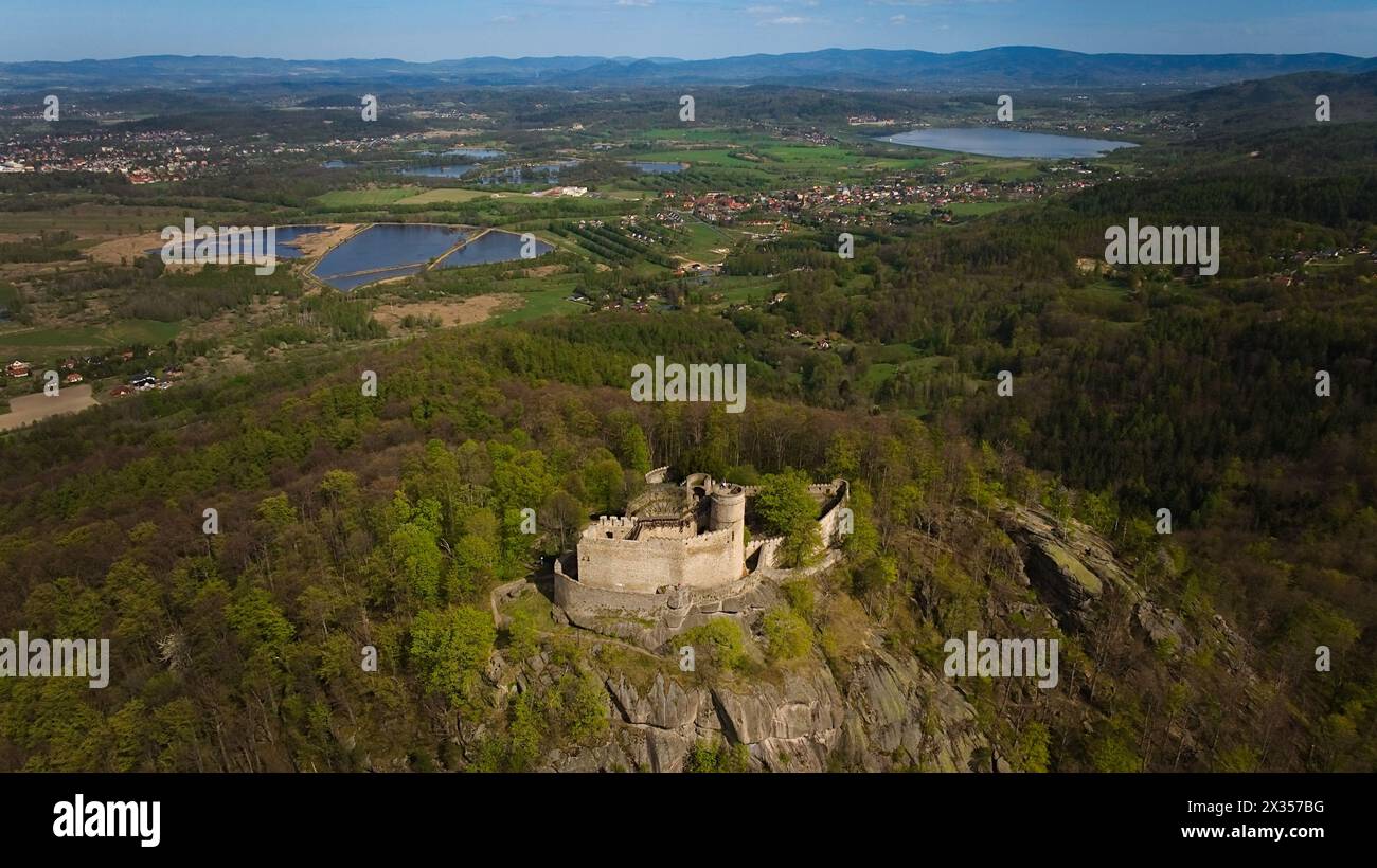 An aerial view captures the medieval Chojnik Castle atop a mountain in ...