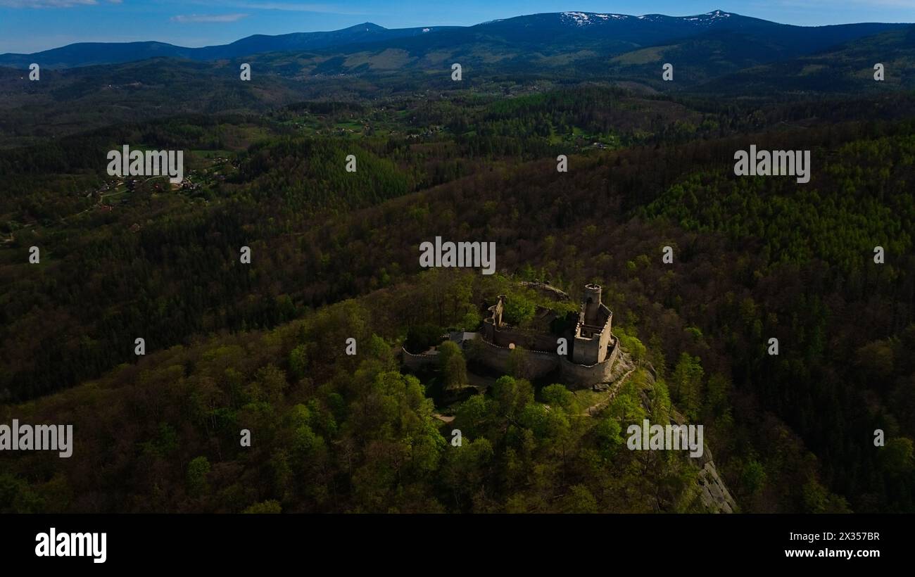 An aerial view captures the medieval Chojnik Castle atop a mountain in ...