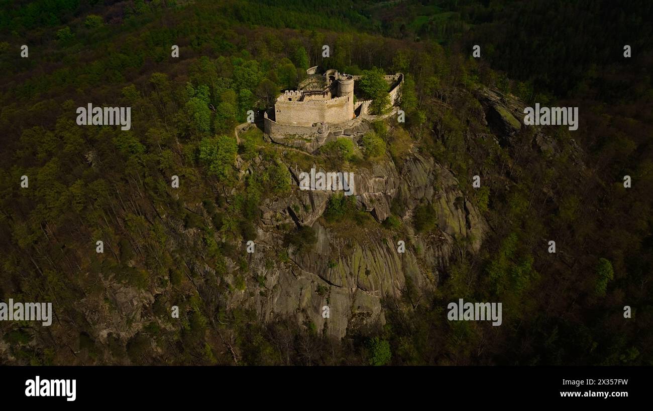 An aerial view captures the medieval Chojnik Castle atop a mountain in ...