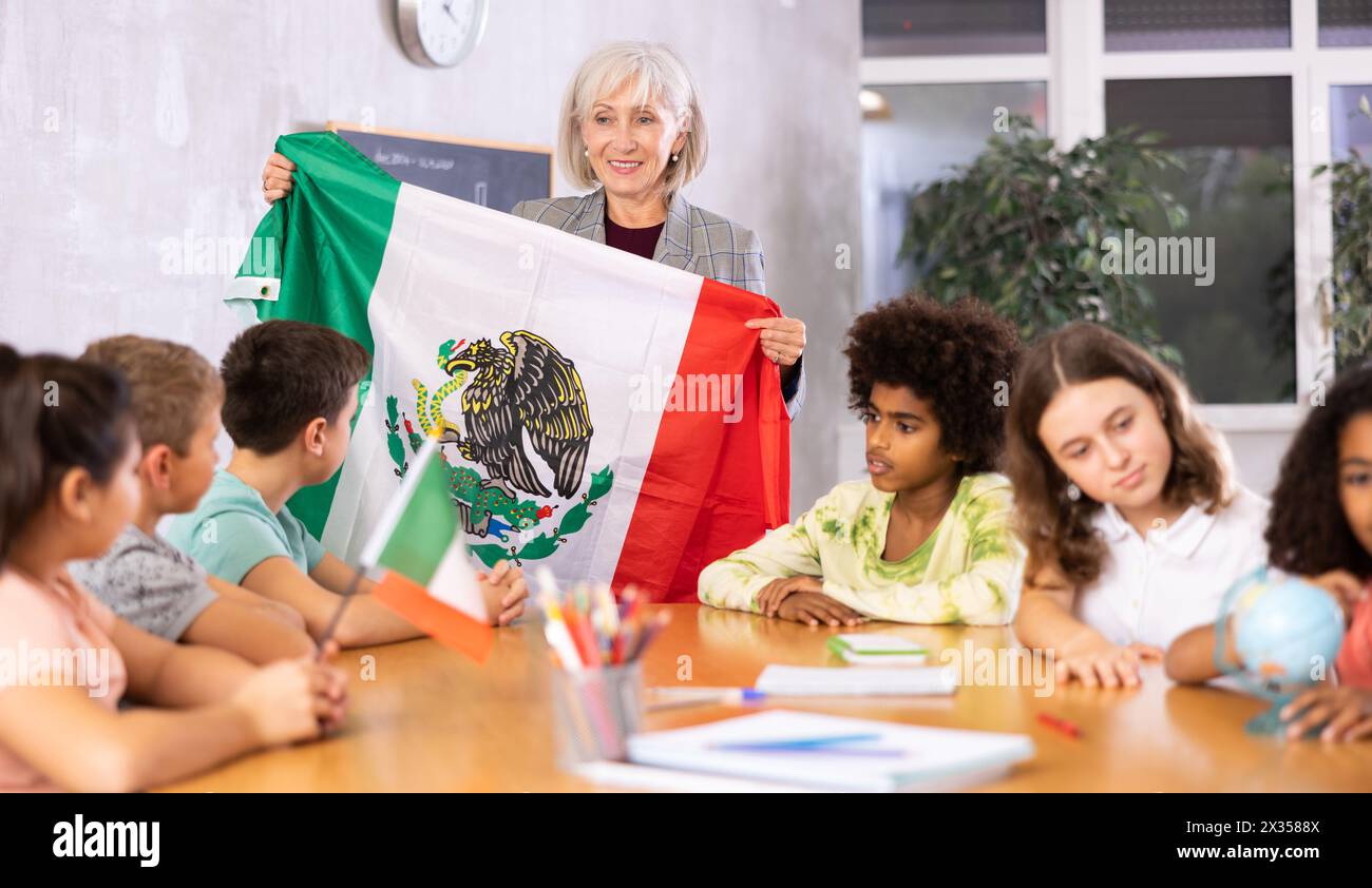 Female teacher showing mexican flag to kids in geography class Stock ...