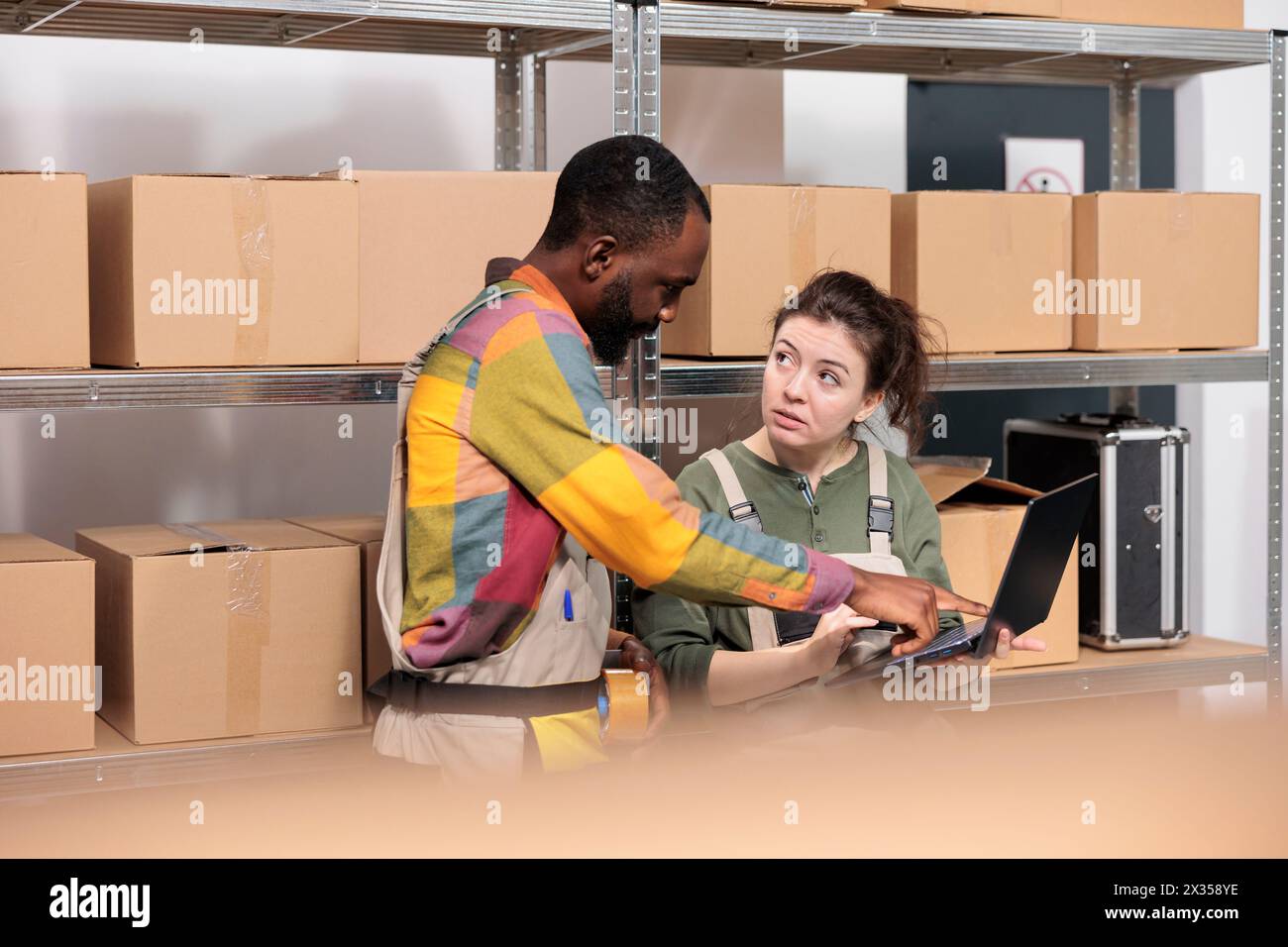 Multi ethnic stockroom supervisor packing parcels and managing delivery ...