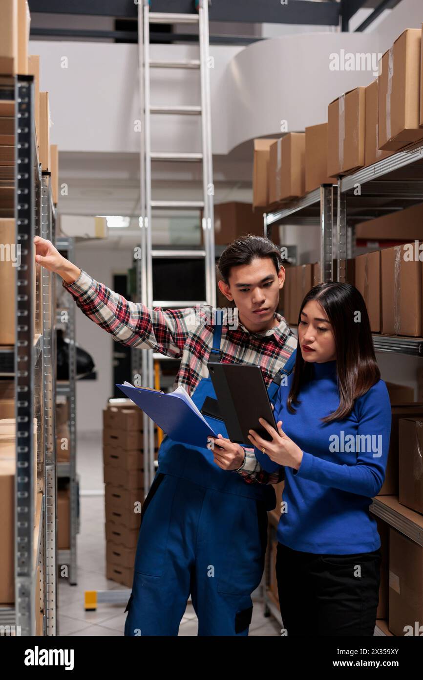 Warehouse employees managing inventory tracking with goods checklist ...