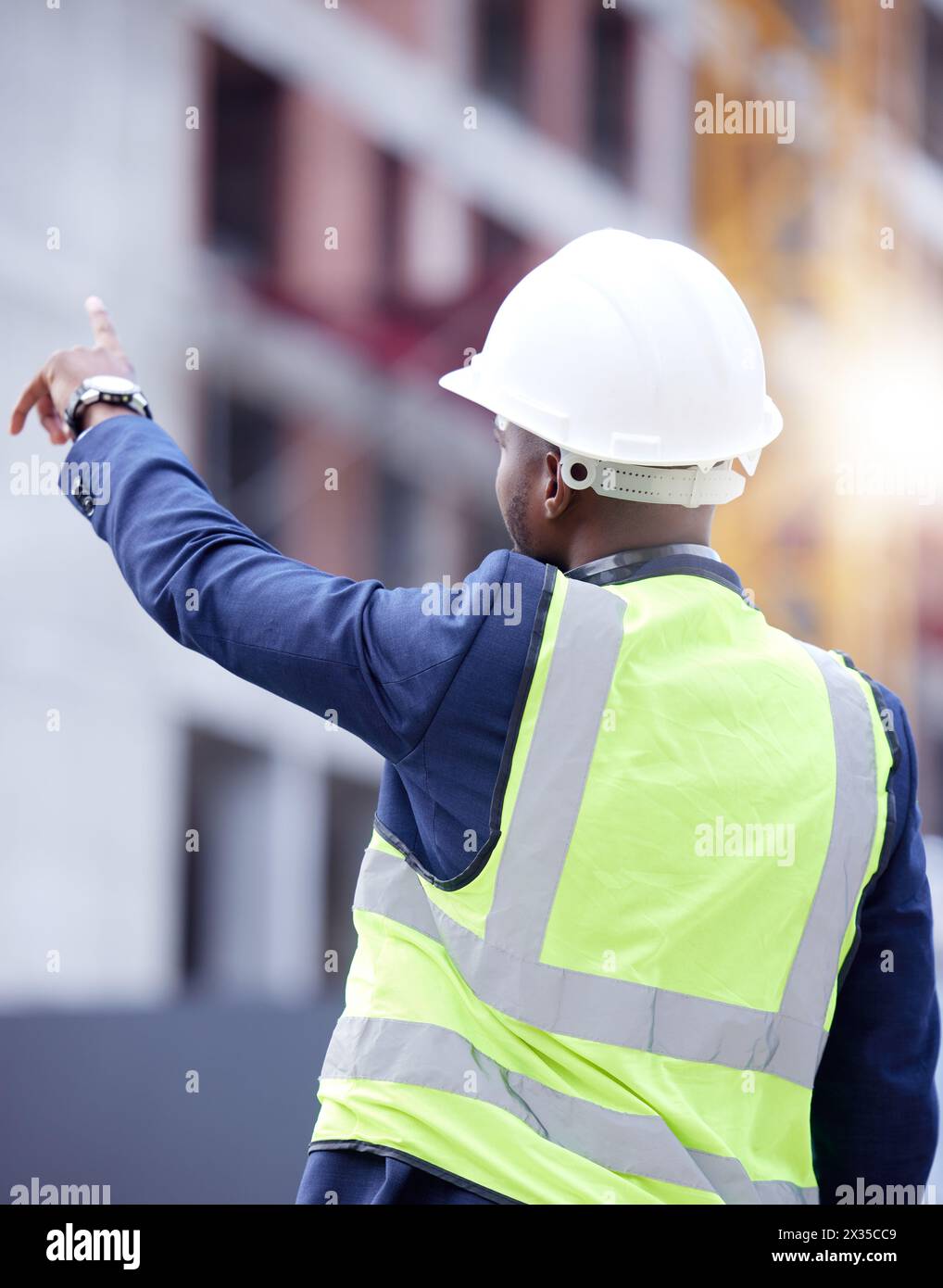 Civil engineering, pointing and man on site in helmet, vest and safety ...