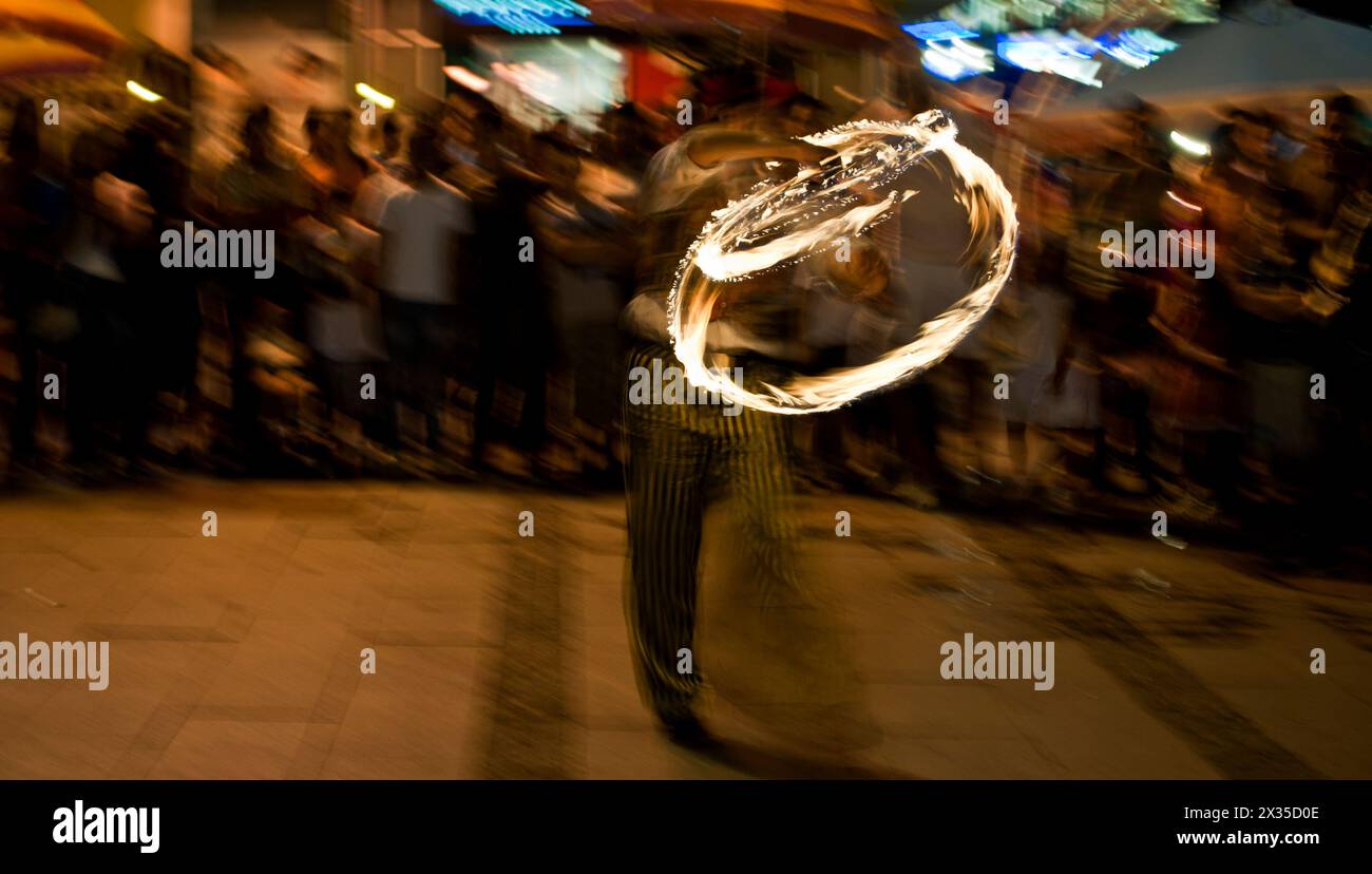 A fire juggler performs during street shows. Image with a longer ...