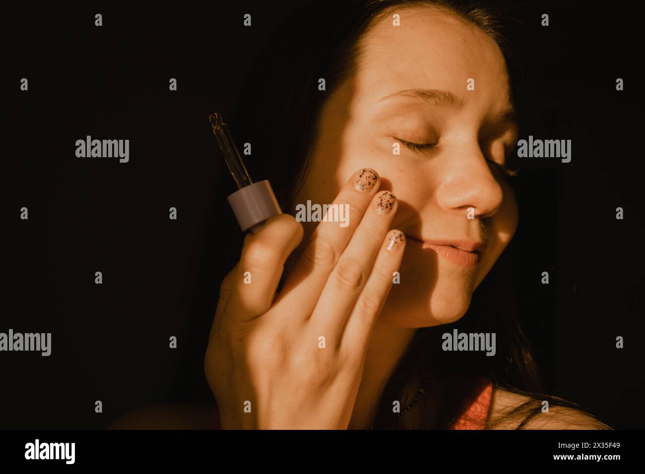 Beautiful white European baby face young woman applying serum from an ...