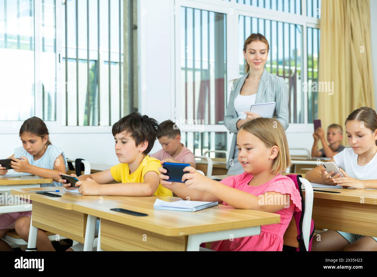 Pupils using mobile phones during lesson in school Stock Photo - Alamy
